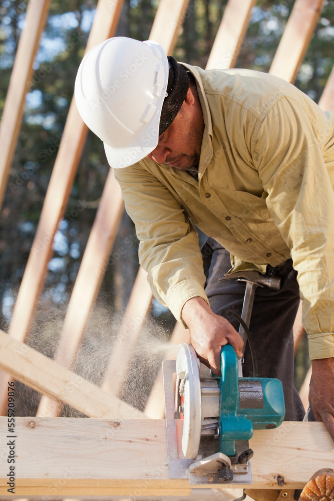 Carpenter using a circular saw on stud Stock Photo | Adobe Stock