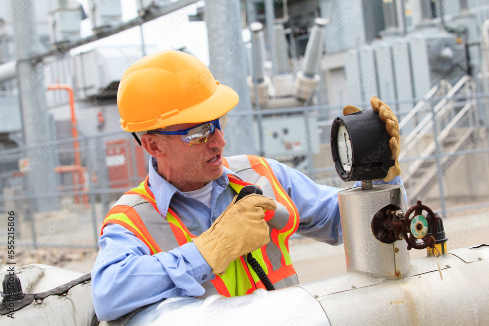 Electrical engineer examining pressure sensor at an electric power ...