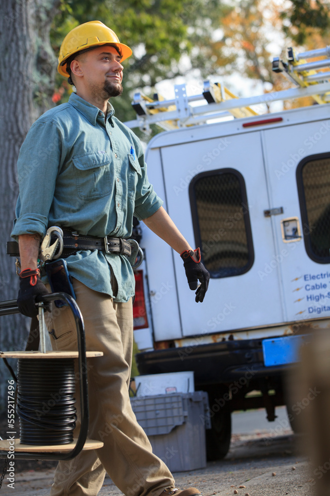 Cable lineman pulling cable from reel at site Stock Photo | Adobe Stock