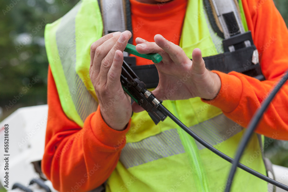 Cable lineman crimping connector to a cable from a bucket truck Stock ...