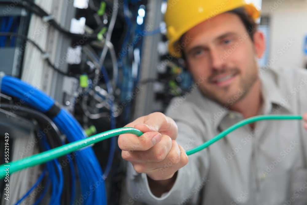 Network engineer pulling cable from reel in network data center Stock ...
