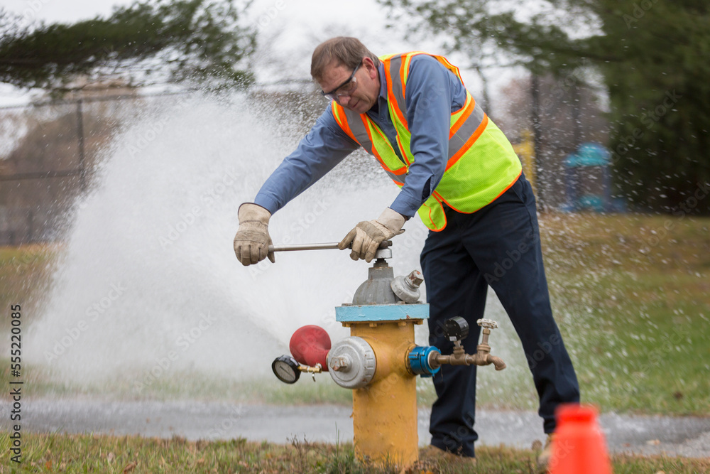 Foto de Water department technician opening fire hydrant to flush water ...