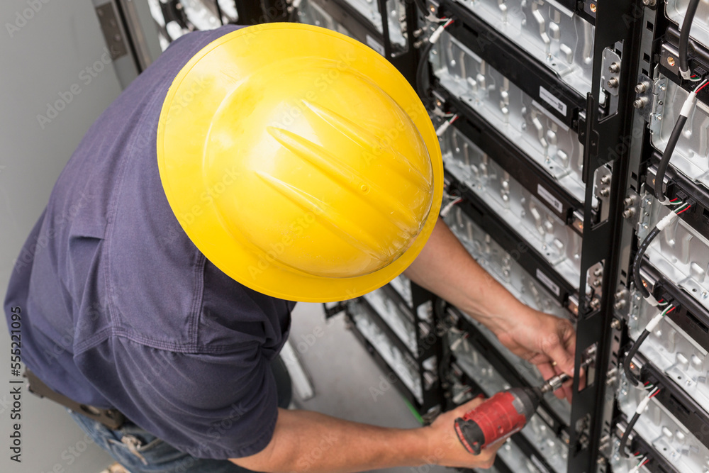 Engineer connecting energy storage batteries for back up power to an ...