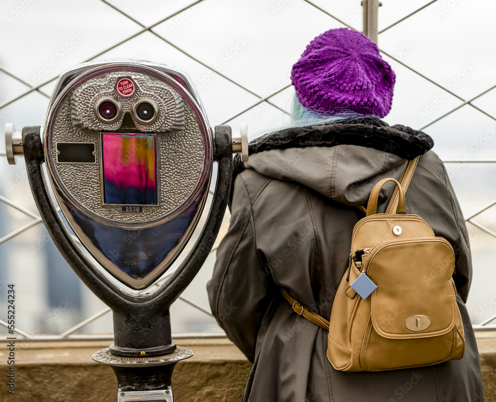 Female tourist standing beside binoculars outside on the observation ...