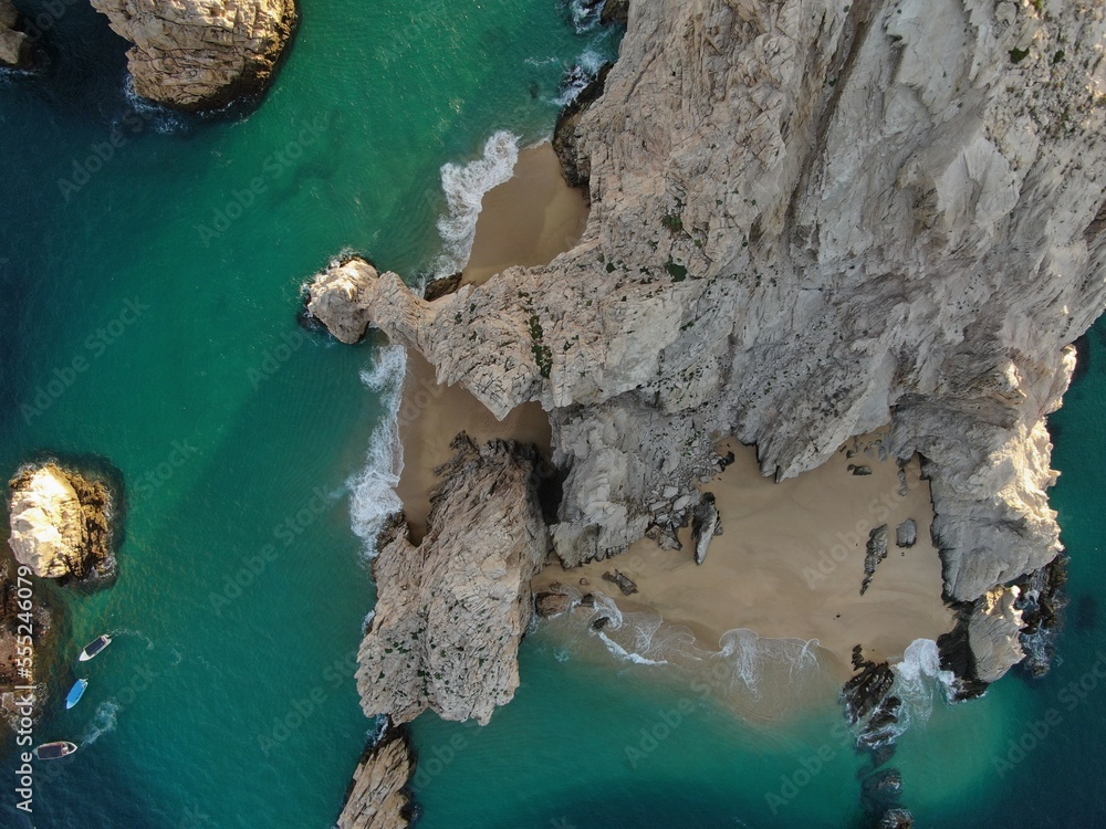 Top down sunset aerial of stone arch and rocky cliffs in Cabo San Lucas ...