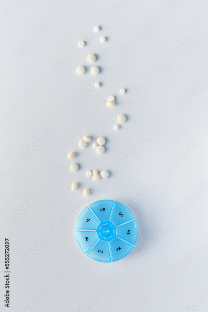 Tablet, pill dispenser and tablets. Flat lay, top view on off white ...