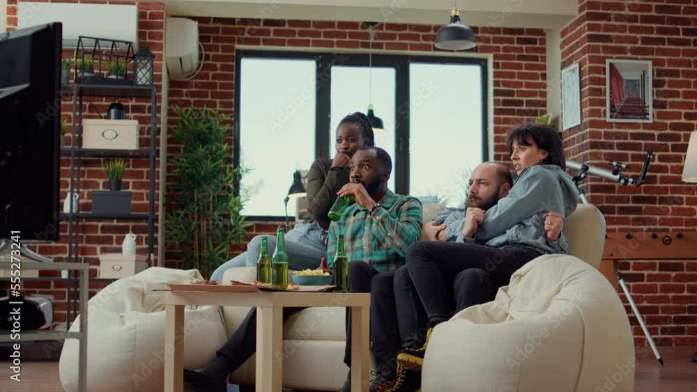 Diverse people getting scared watching horror movie on television ...