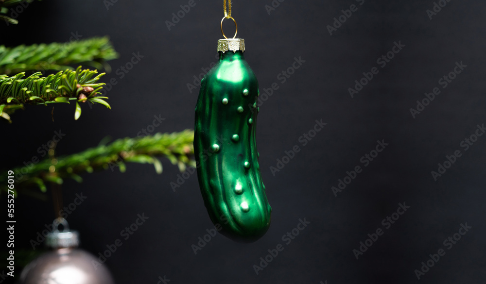Christmas tree decorations. A green glass cucumber is hanging on a ...