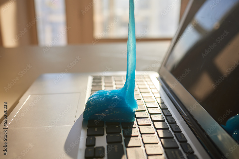 Blue soft gel cleaning dust on keyboard. Concept cleaning your computer ...