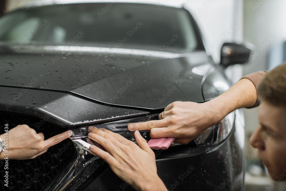 Close up of protection film installation on front headlight of modern ...