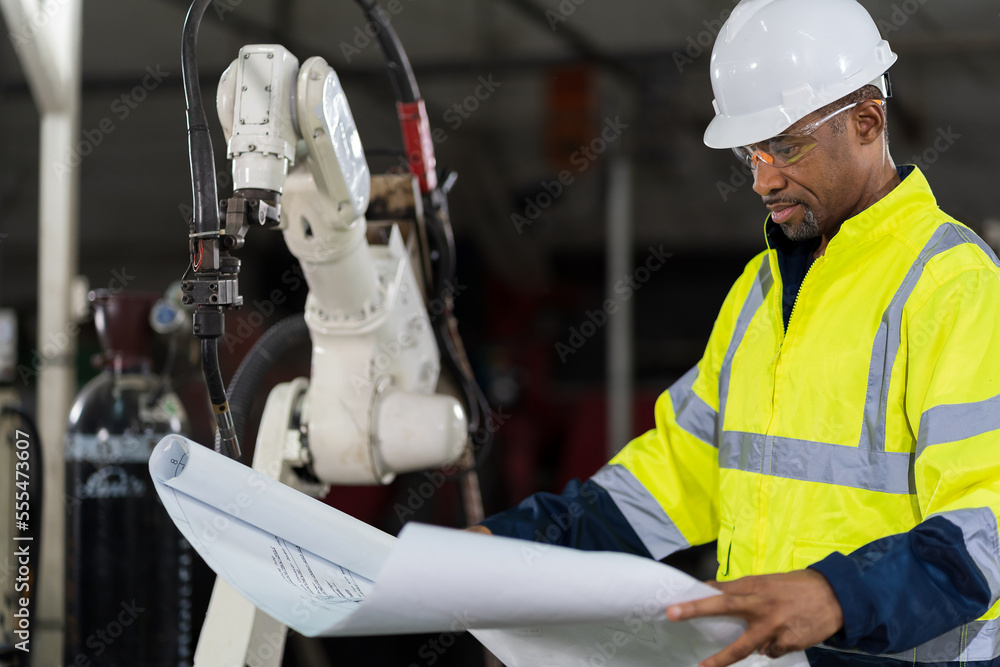 African American male engineer worker holding blueprint structure for ...