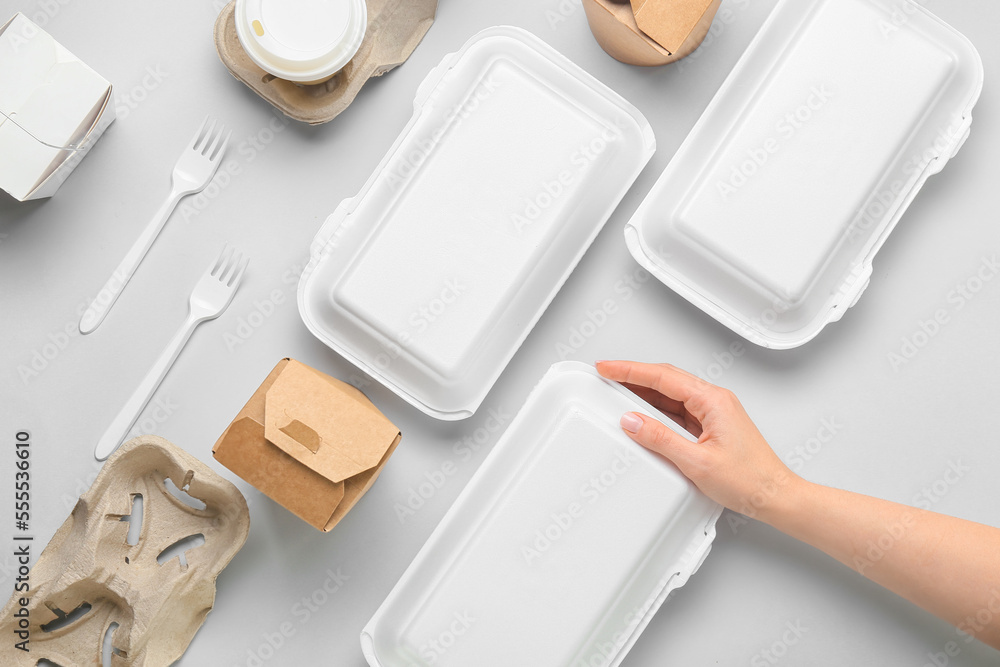 Female hand and different food containers on light background Stock ...