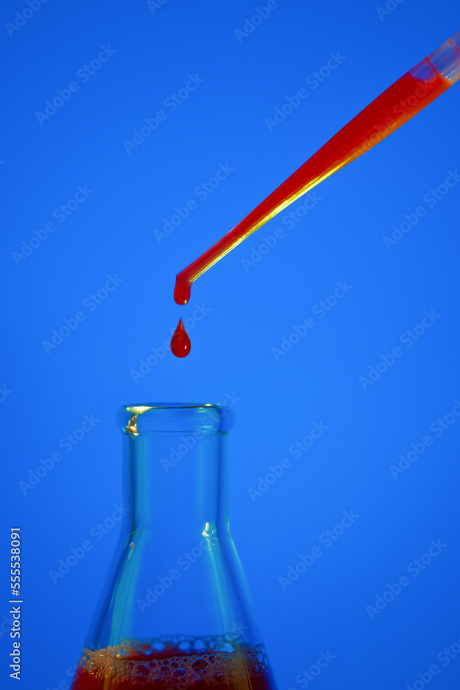 A drop of blood. Pipette. On a blue background. Medical flask with red ...