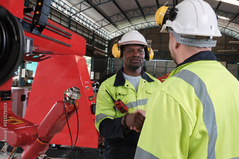 Two male engineers handshake cooperation for robotic arm development ...