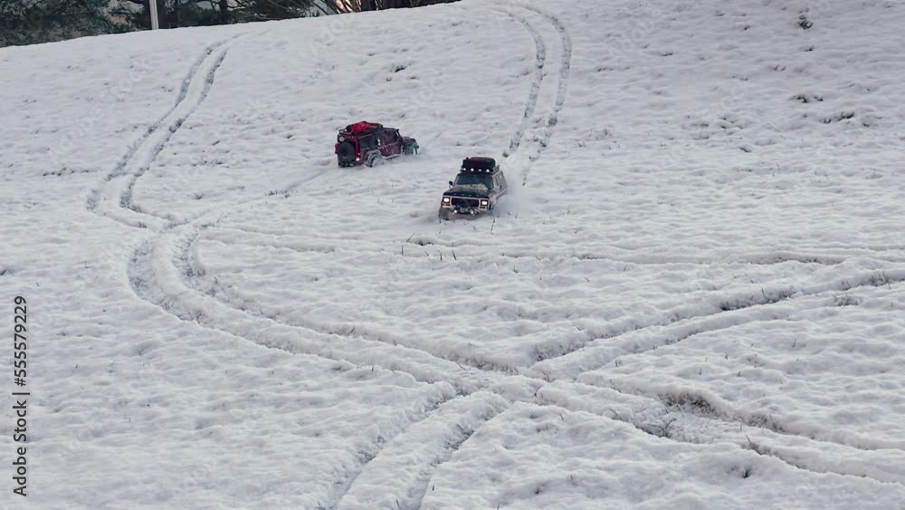 Remote control cars drive in the snow. The RC crawlers have four-wheel ...