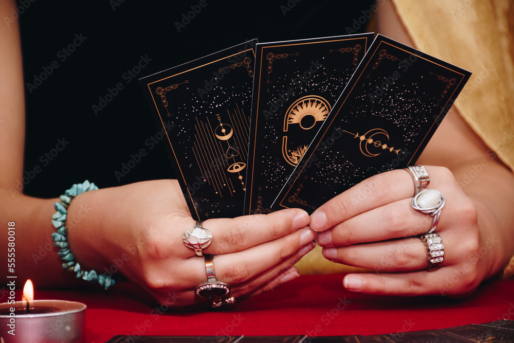 Tarot reader or Fortune teller of hands holding up black deck tarot ...