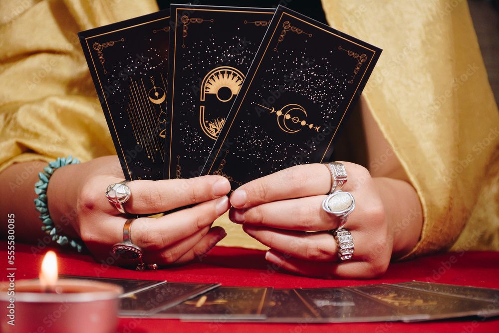 Tarot reader or Fortune teller of hands holding up black deck tarot ...