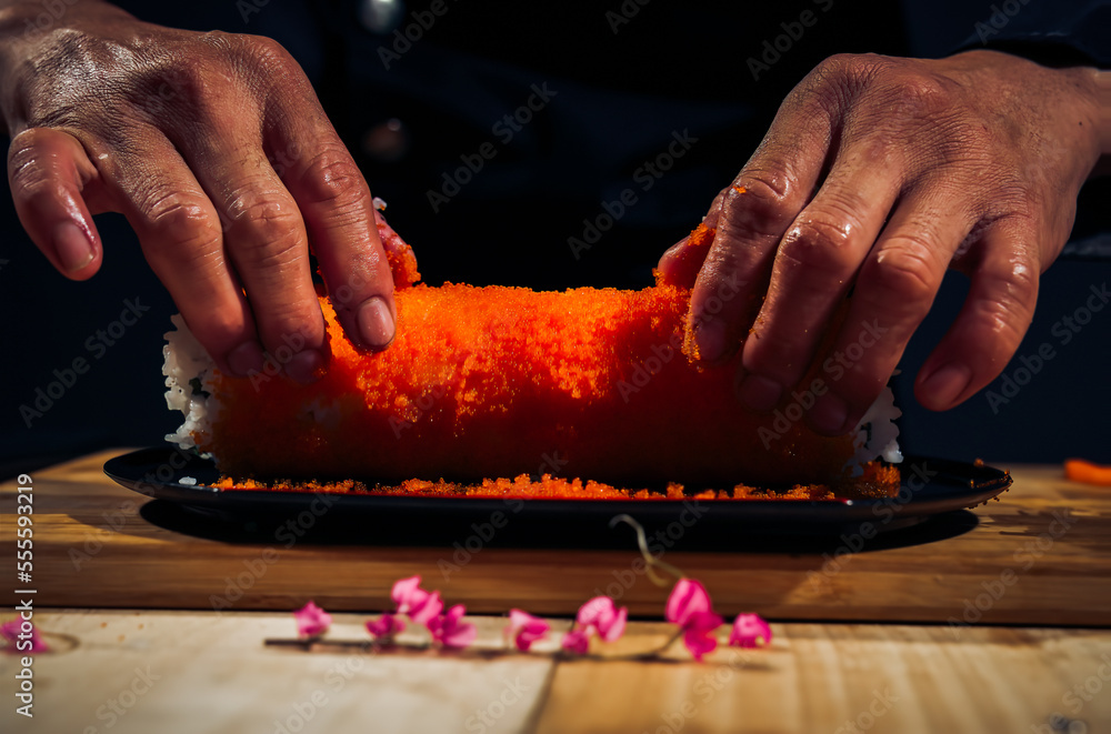 Japanese chef making California Maki Sushi with Masago - Roll made of ...