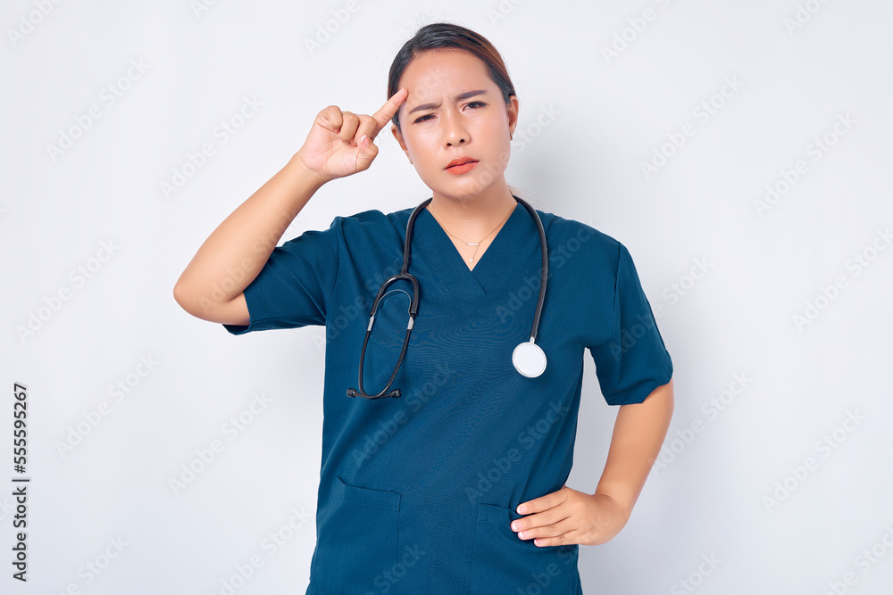 Disappointed angry young Asian woman nurse wearing blue uniform with a ...
