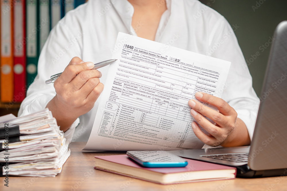 Hand holding of form 1040. U.S. individual income tax return while ...