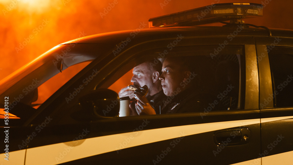 Portrait of Two Police Patrol Officers Sitting in the Car Eating Donuts ...