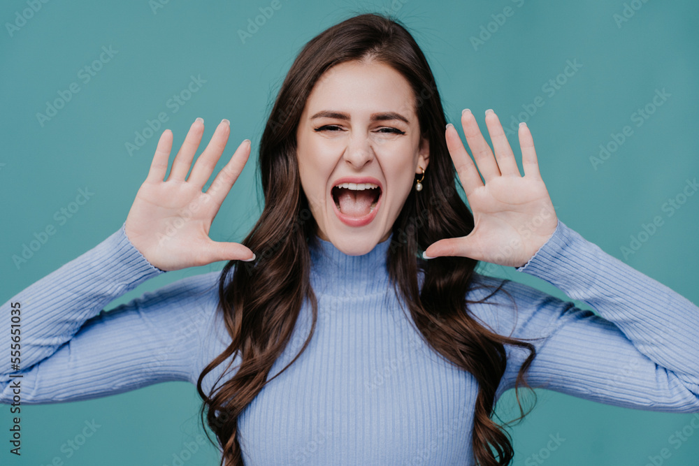 Loud screaming brunette angry girl in lilac sweater with opened moth ...