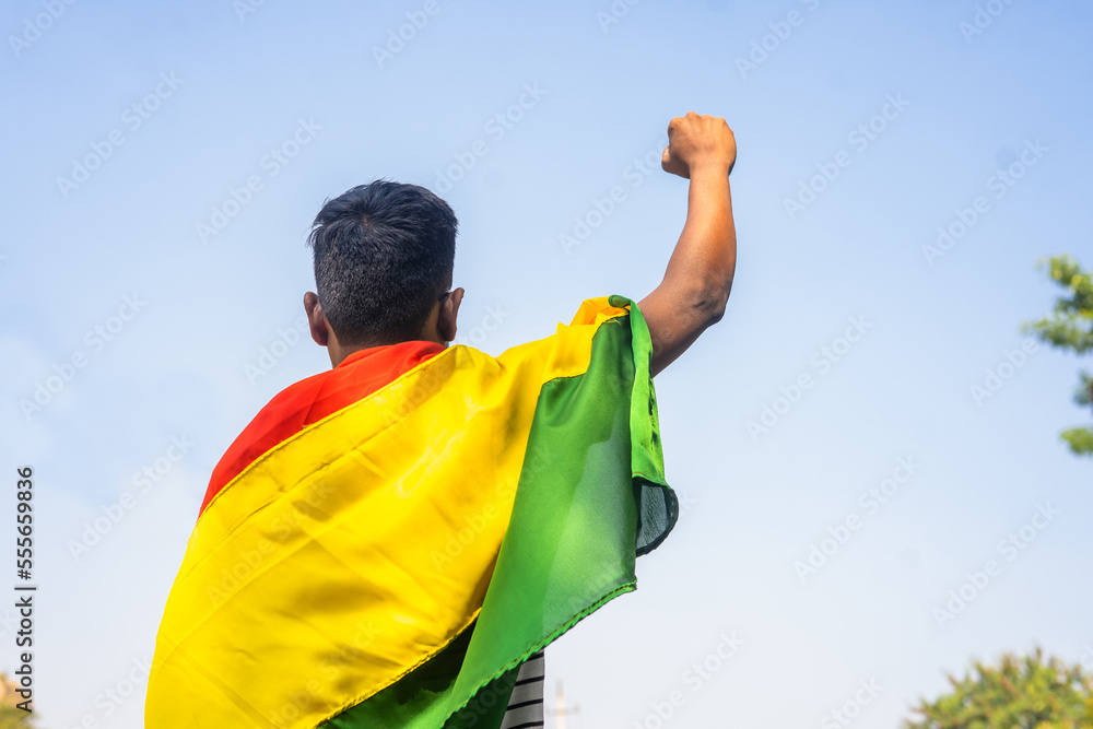 Back view shot of man with black history month flag on shoulder by ...