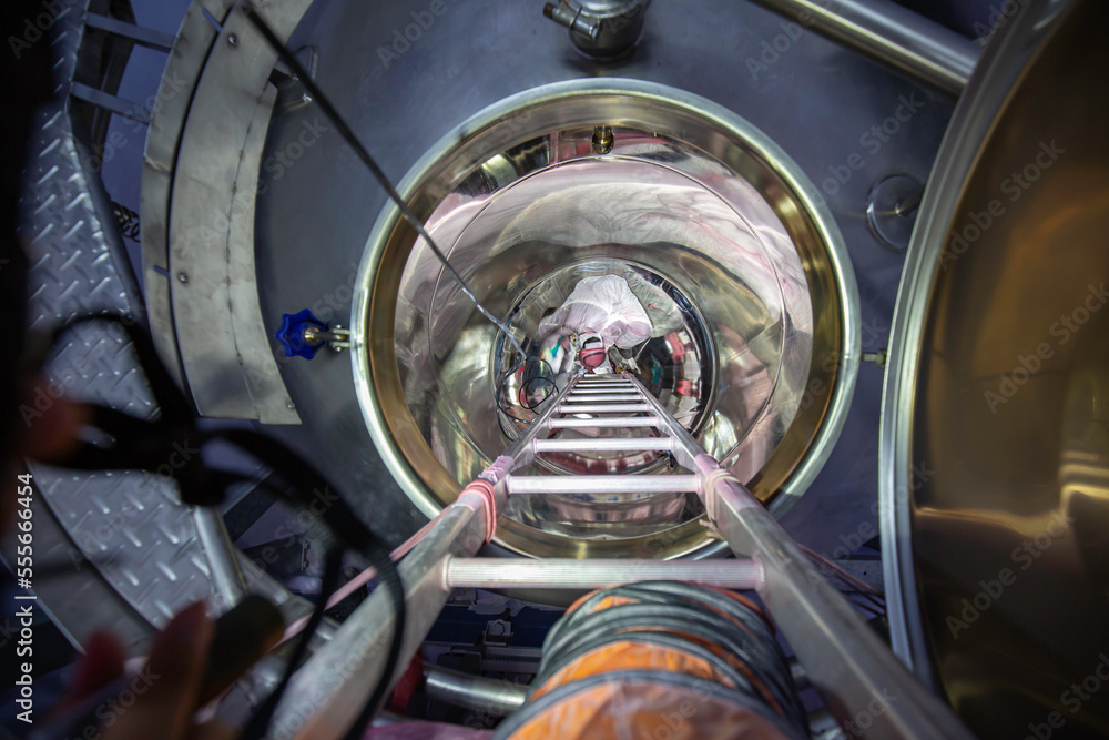 Inside male worker into the inspection shiny tank stainless chemical ...