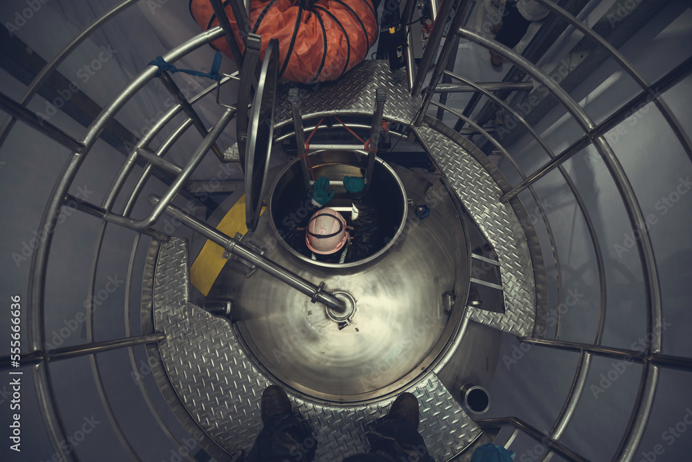 Top view male climb up the stairs into the tank stainless chemical ...