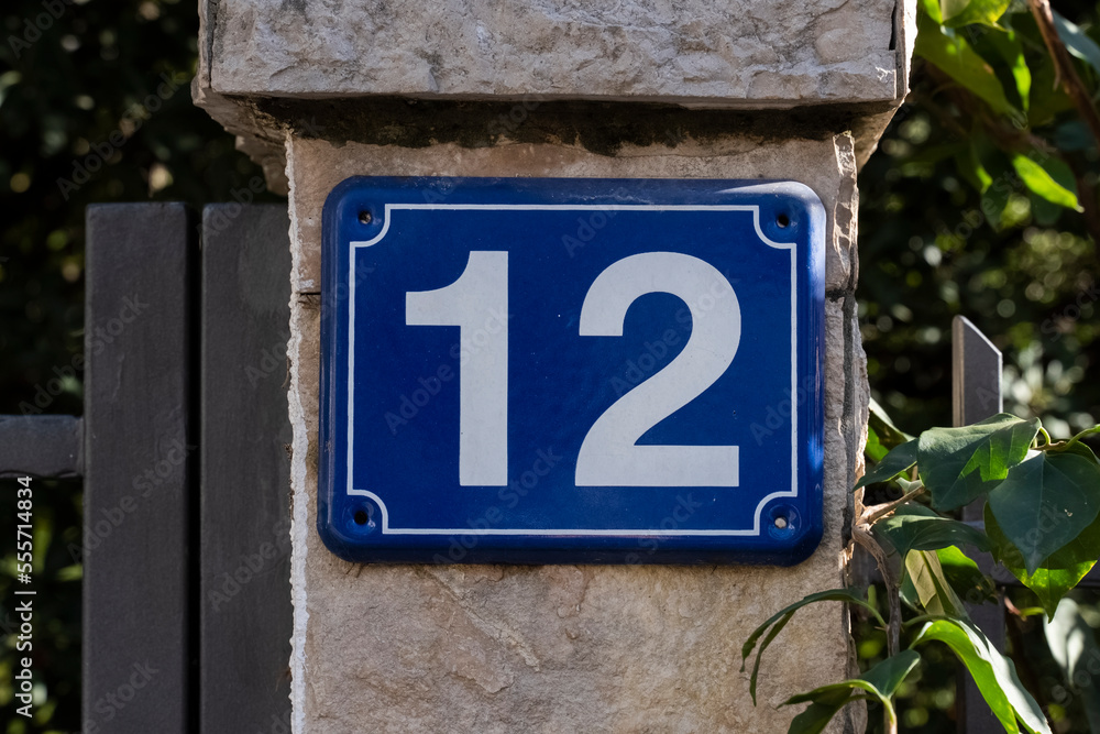 close-up of a rectangular sign signifying the house number with white ...