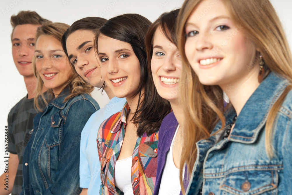 Close-up portrait of six, young men and young women in a row, smiling ...