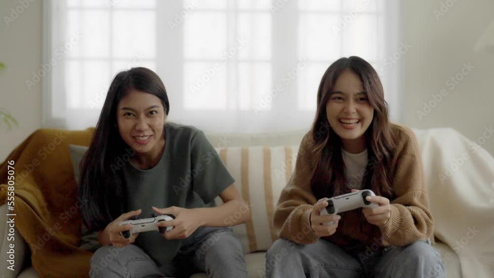 Two people beautiful young asian woman sitting on sofa and holding ...