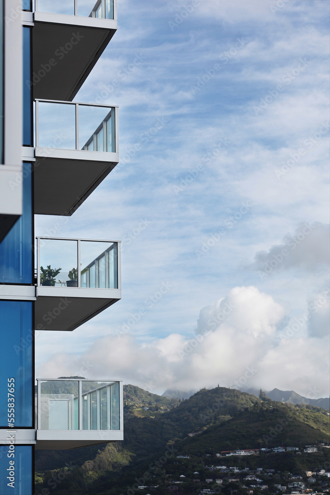 Luxury high-rise apartment building balconies overlooking green forest ...