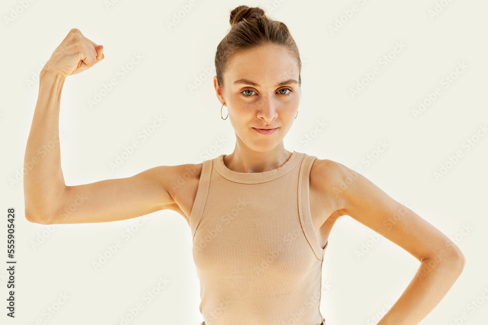 Strong enthusiastic woman showing her strong biceps, looking at camera ...