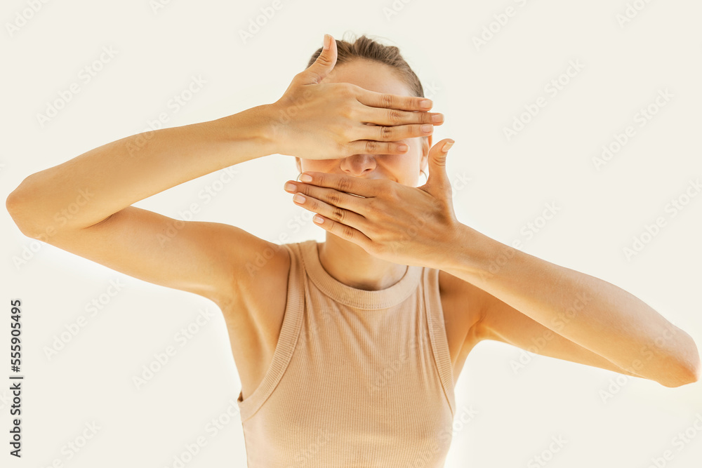 Cute funny young girl hiding behind her hands, covering her face with ...