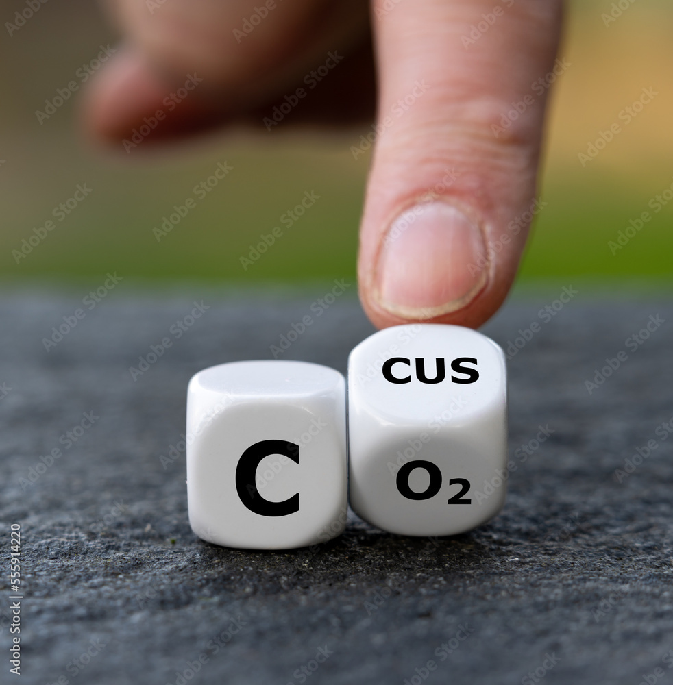 Symbol for carbon capture, utilization and storage (CCUS). Hand turns ...