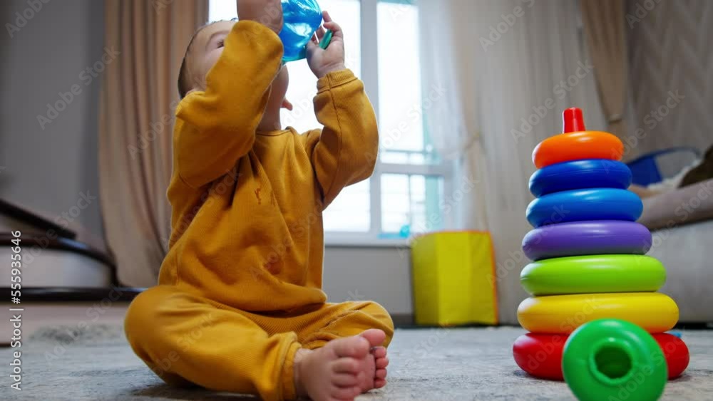 Cute baby boy drinks from bottle spilling the water. Lovely toddler on ...