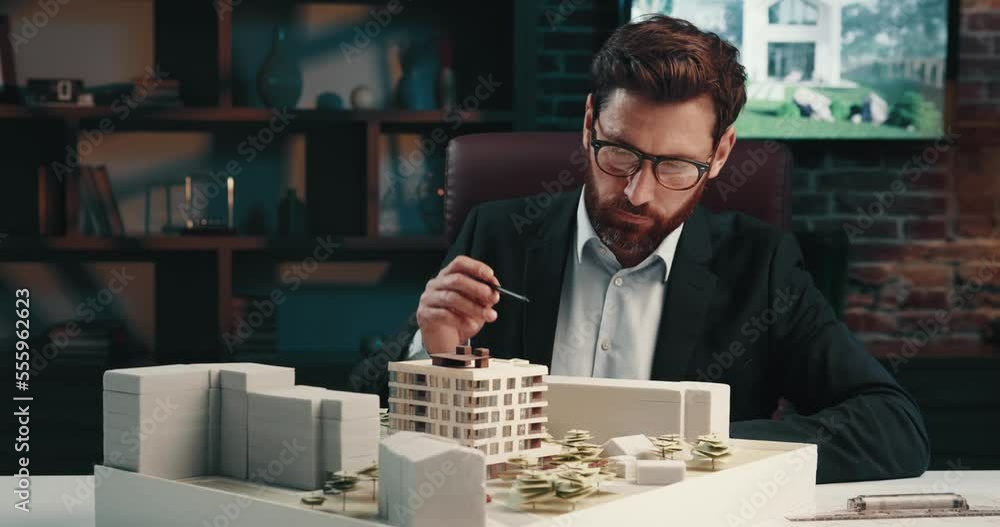 Successful man checking the layout of a building during work at the ...