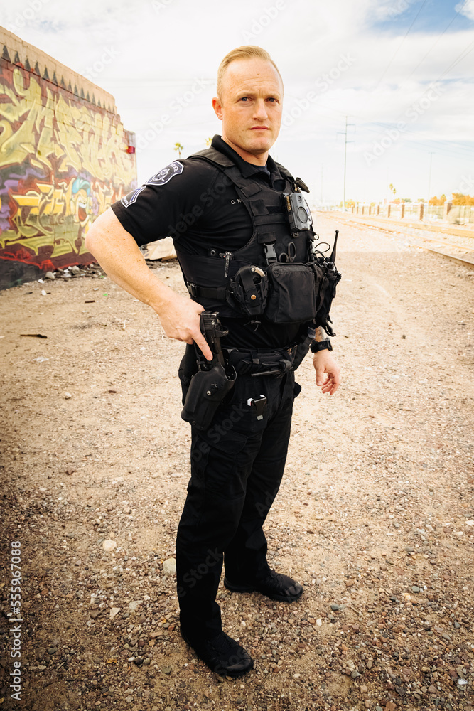 Vertical image of white male caucasian police officer reaching down and ...