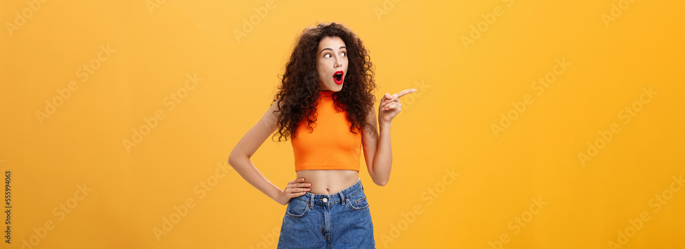 Woman peeking at neighbours window being surprised and amazed pointing ...