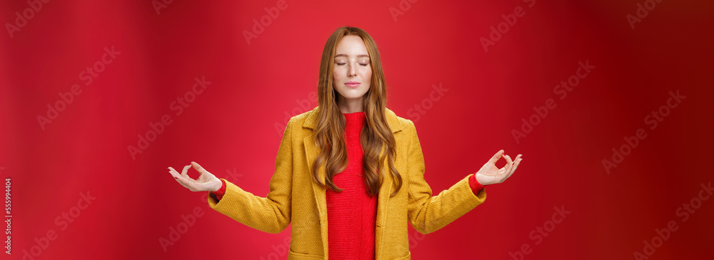 Girl keep calm releasing stress with meditation, posing in yellow coat ...