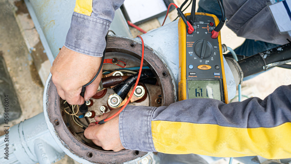 A multimeter is being used by an electrician to check the resistance ...