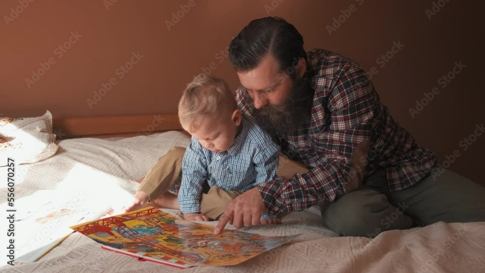 father and son reading a book. dad teaches a little boy to read. dad ...