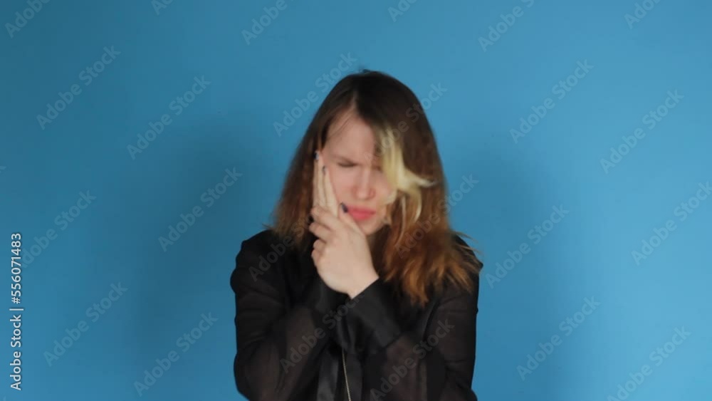 Vidéo Stock An unhealthy girl pushes and rubs her cheek, winces from ...