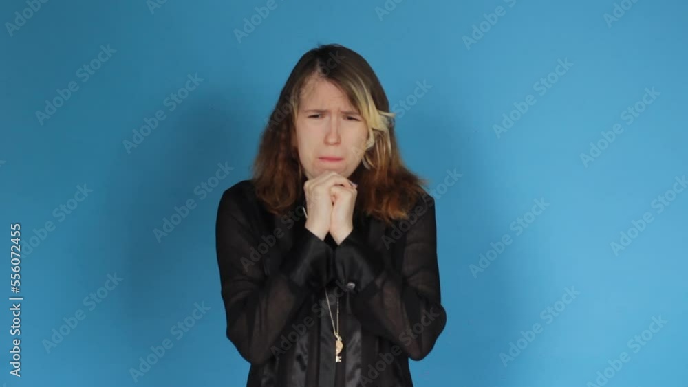 A close-up portrait of a sad young woman praying, hoping, pleading for ...