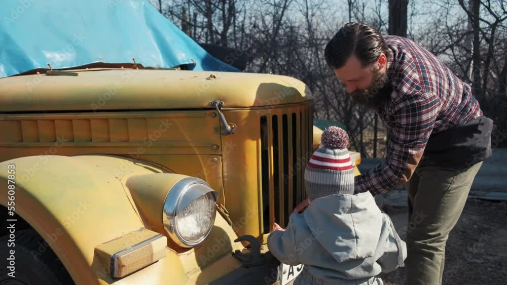 dad shows the car inside. dad opened the old car and shows his son the ...