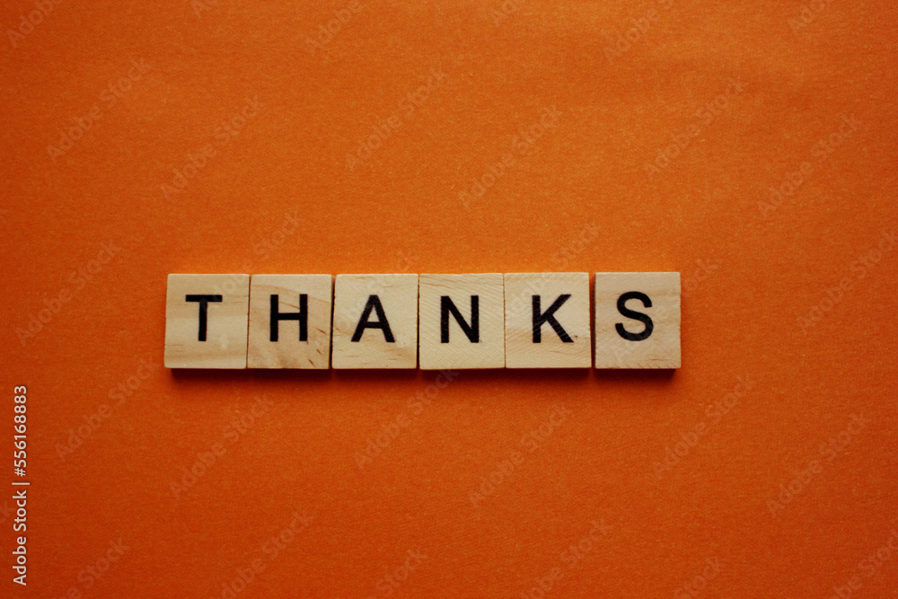 Wooden cubes with the inscription thanks. Beautiful orange background ...