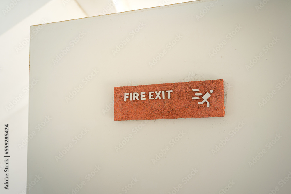 An emergency fire exit direction plate that installed on the white door ...