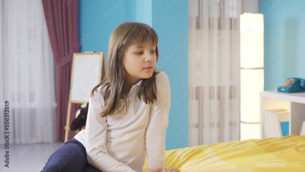 Lonely little girl looking thoughtfully around her room. Boring city ...