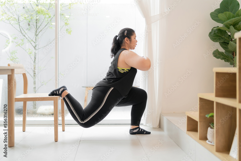 overweight female person workout using chairs in living room single leg ...